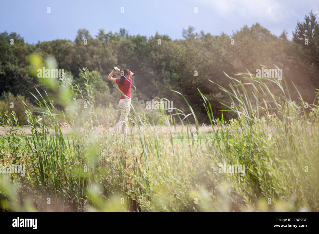 A female golfer teeing off Stock Photo - Alamy