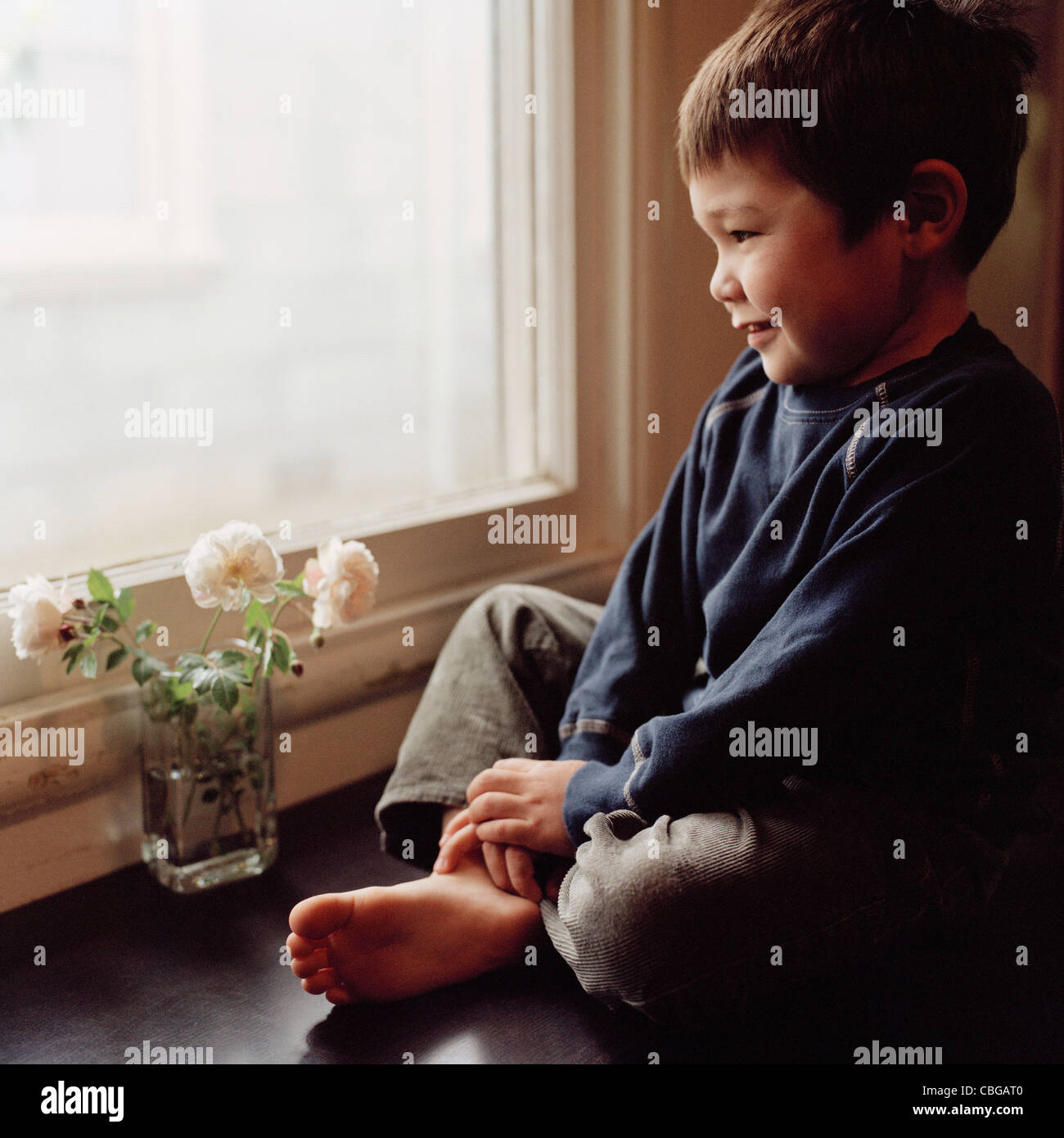 A smiling boy staring out window Stock Photo - Alamy