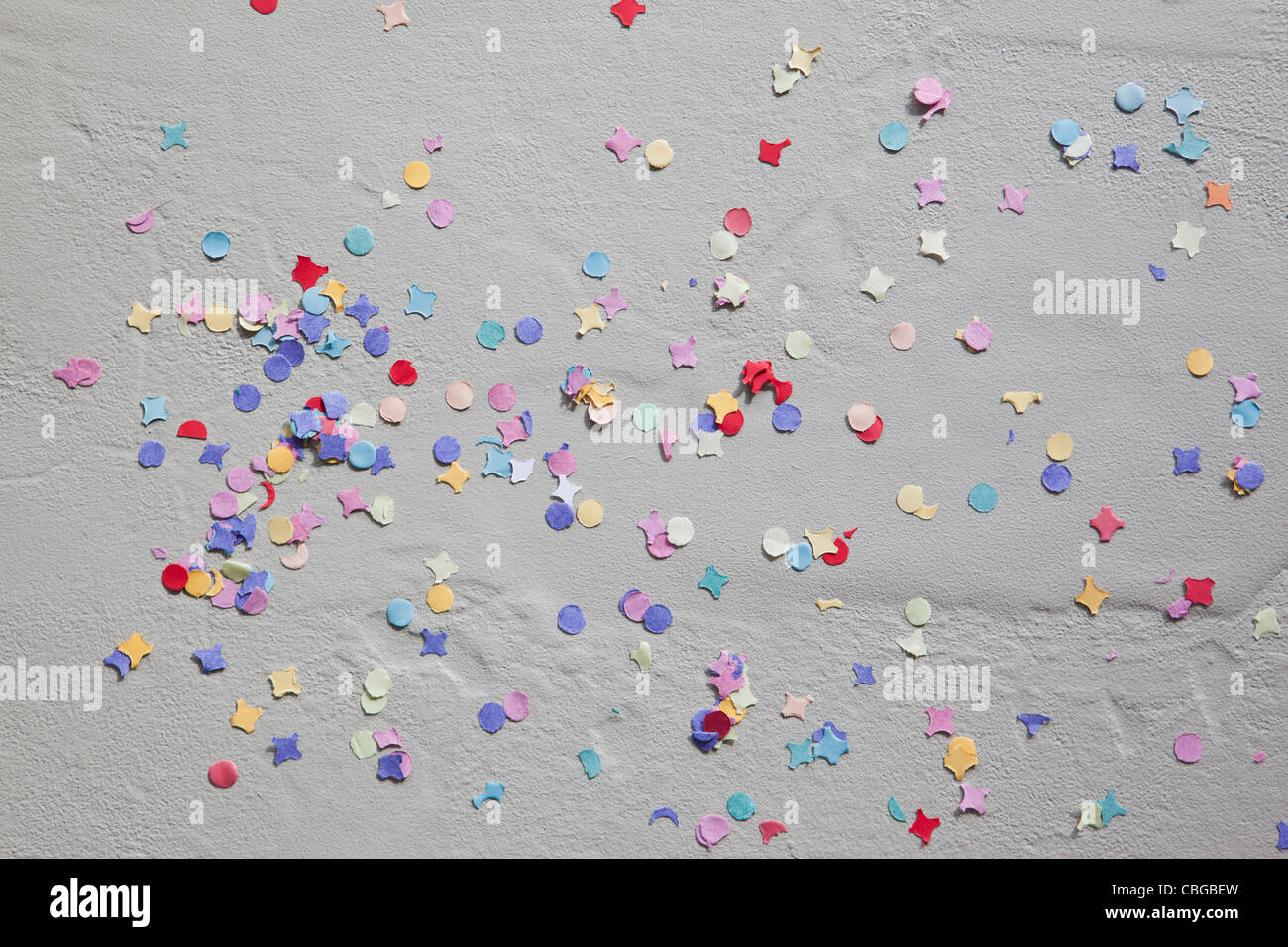 Multi colored confetti on a gray background Stock Photo - Alamy