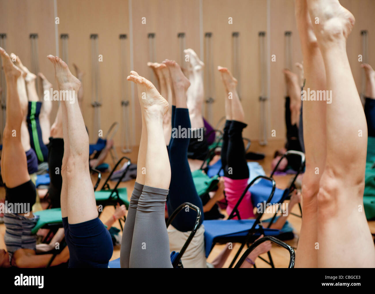 Group of people in Gym, upside down with legs stretched Stock Photo - Alamy