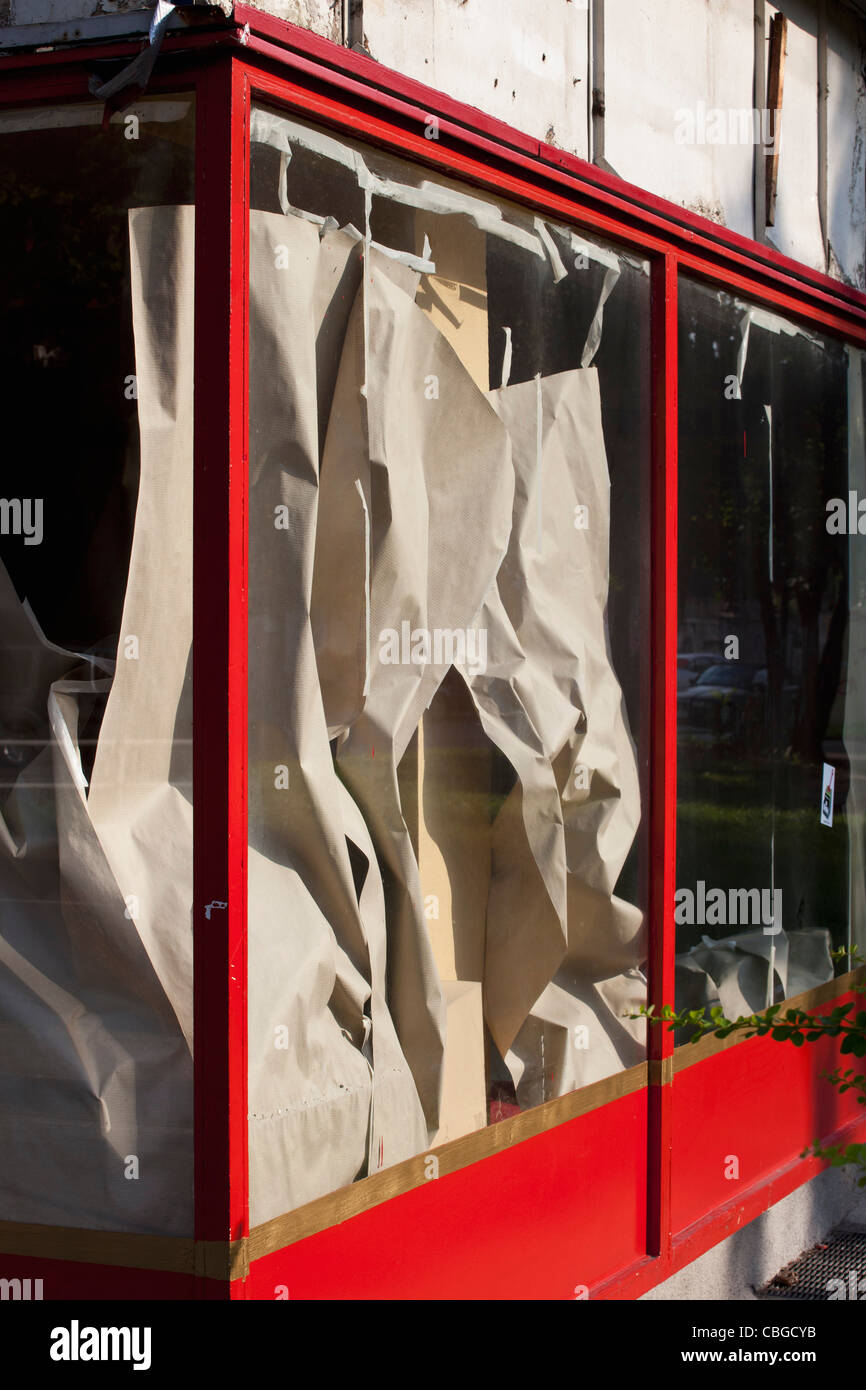 Messy paper covering behind front window Stock Photo - Alamy
