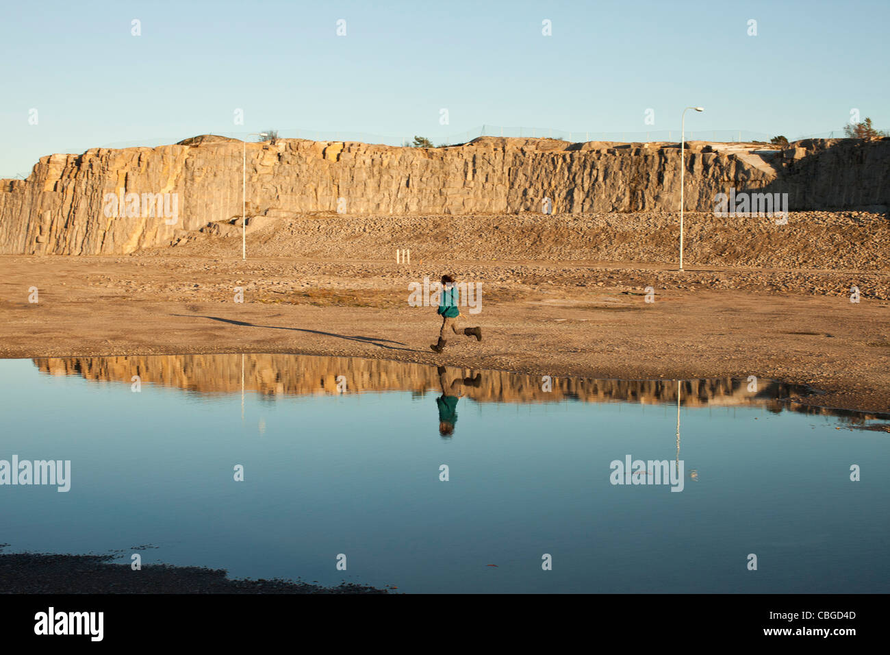 Boy running with reflection in lake Stock Photo - Alamy