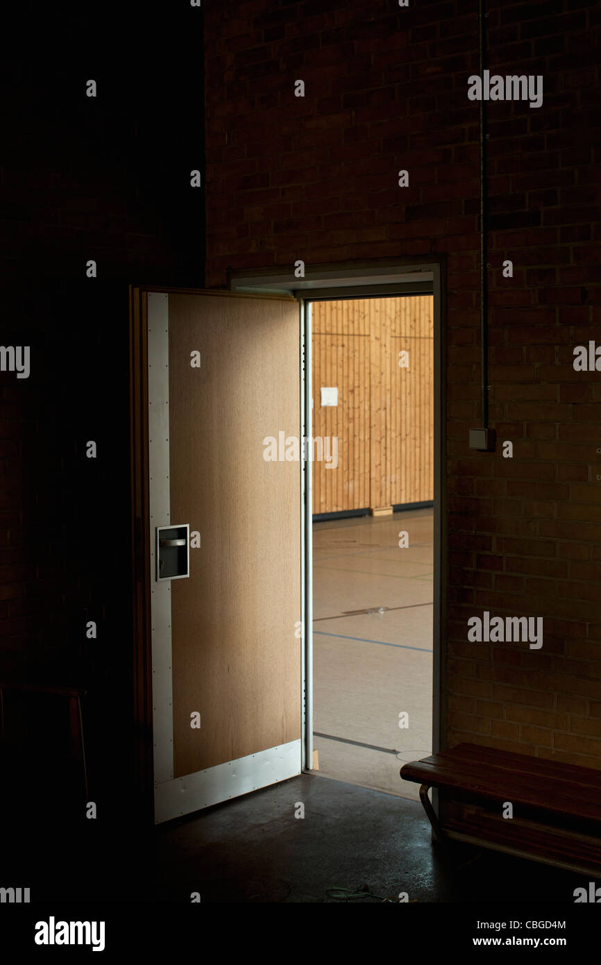 Dark room with door open revealing gym Stock Photo - Alamy