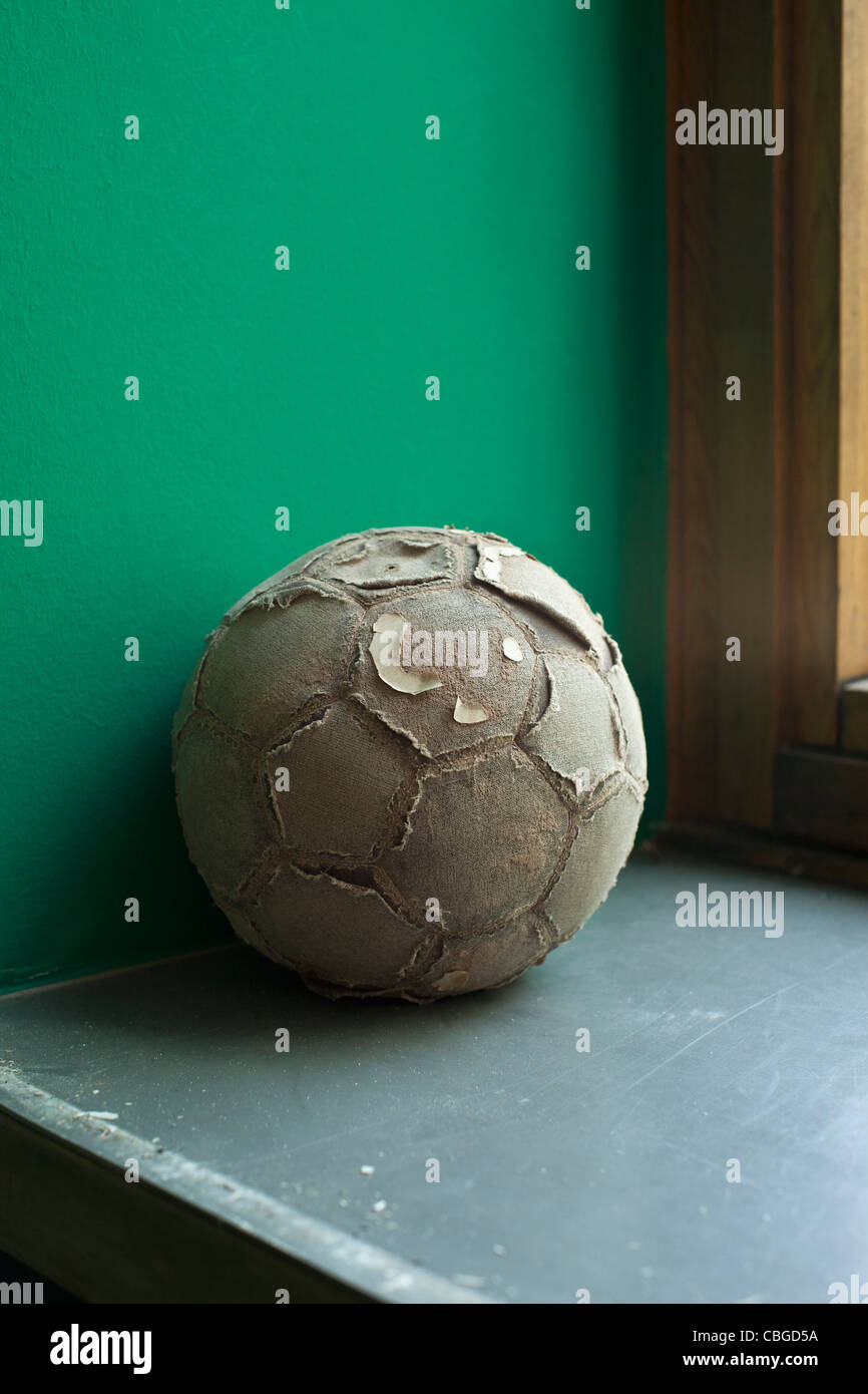 Worn out soccer ball on ledge Stock Photo - Alamy