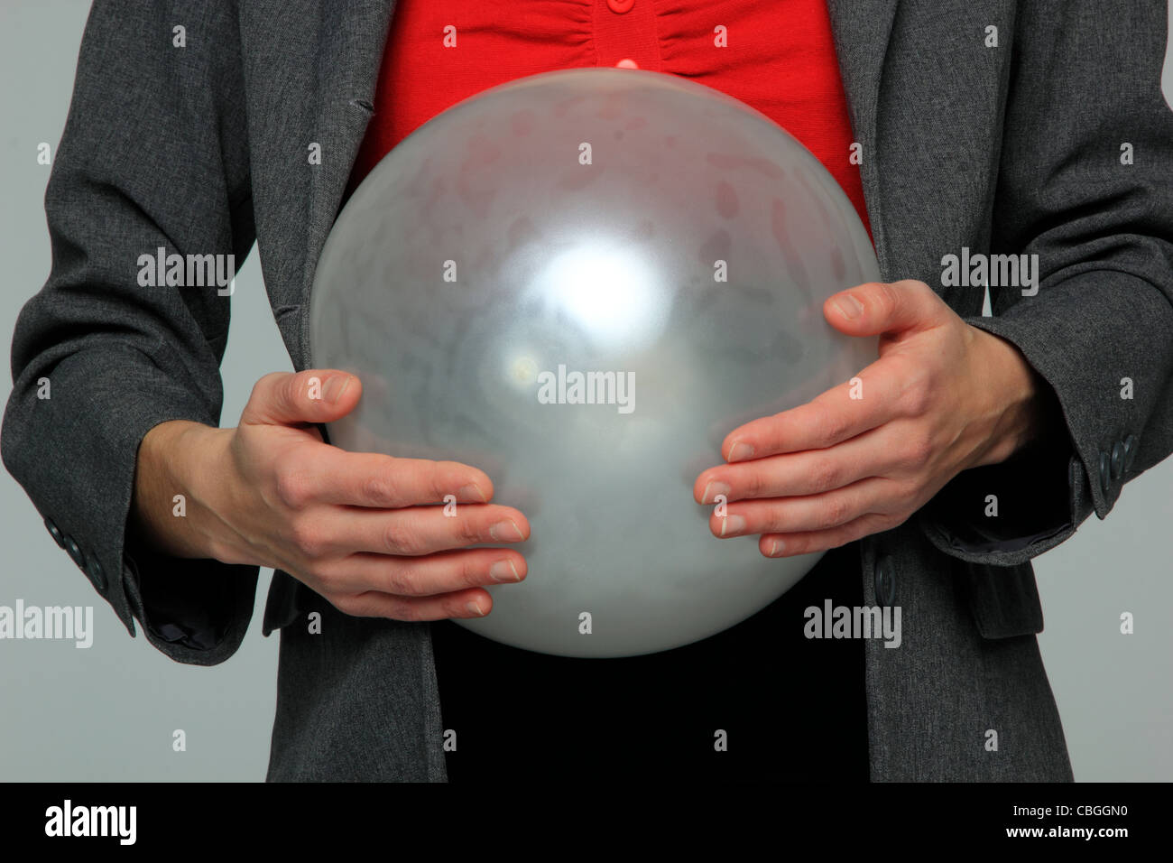 Business woman holding a balloon in front of her belly Stock Photo - Alamy