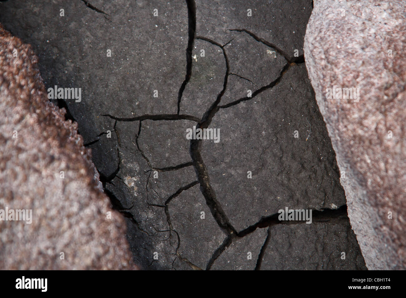 Cracked soil between rocks Stock Photo - Alamy