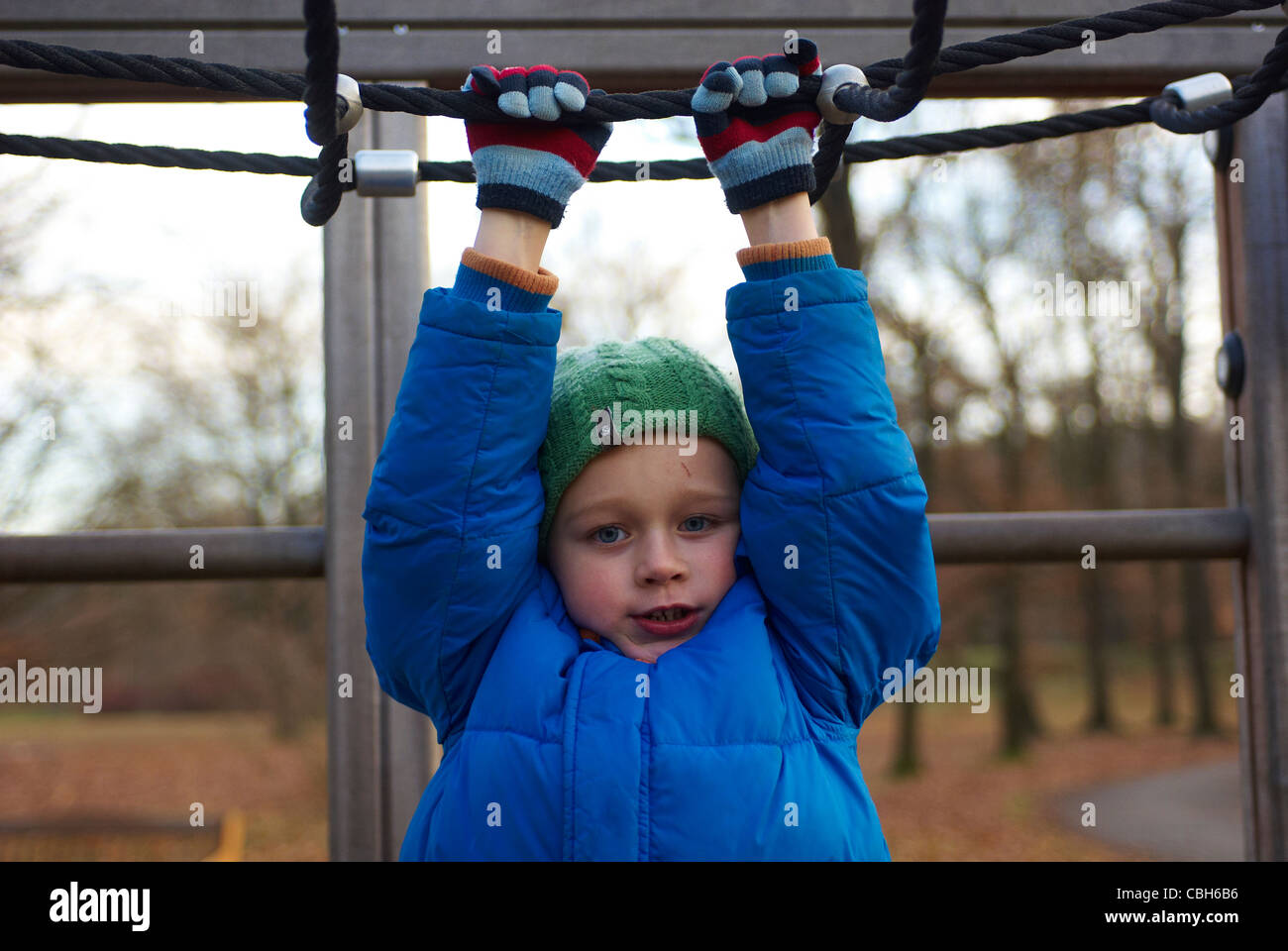 A child blond boy 5 years on a playground, rope net, slide, accident ...