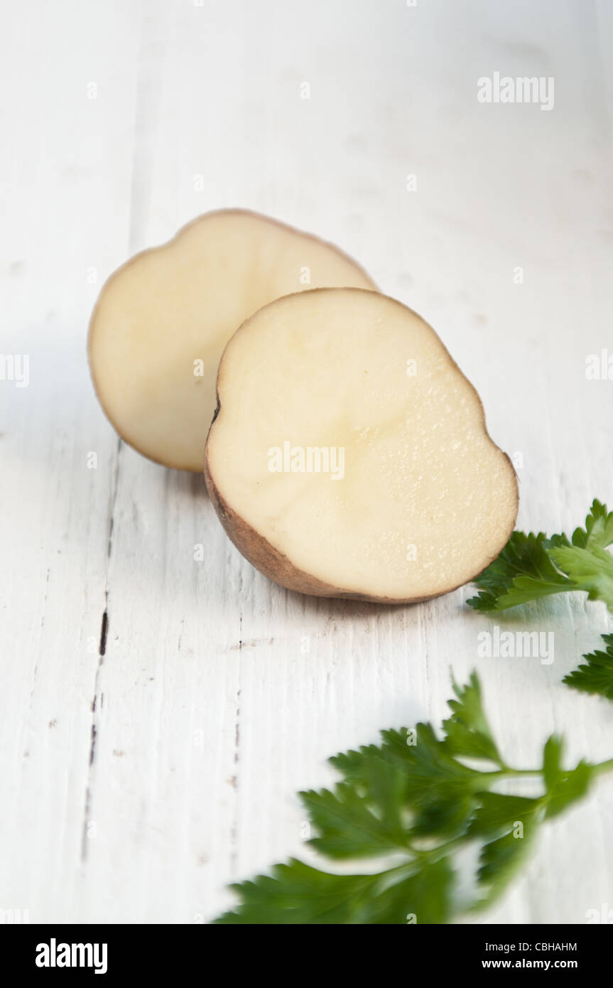 Cut raw potato in half uncooked on a white background Stock Photo - Alamy