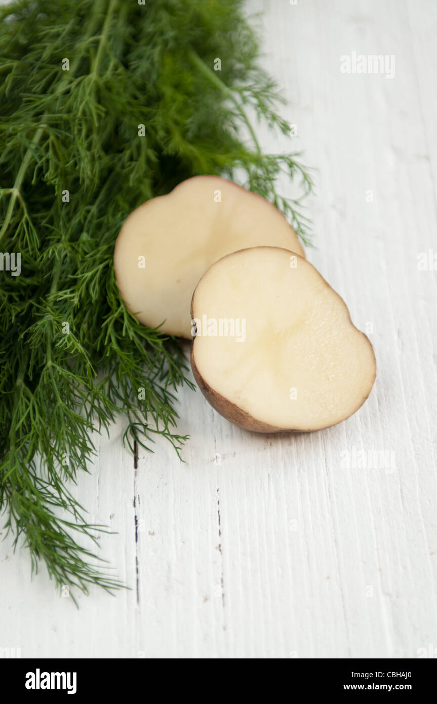 Cut raw potato in half uncooked on a white background Stock Photo - Alamy