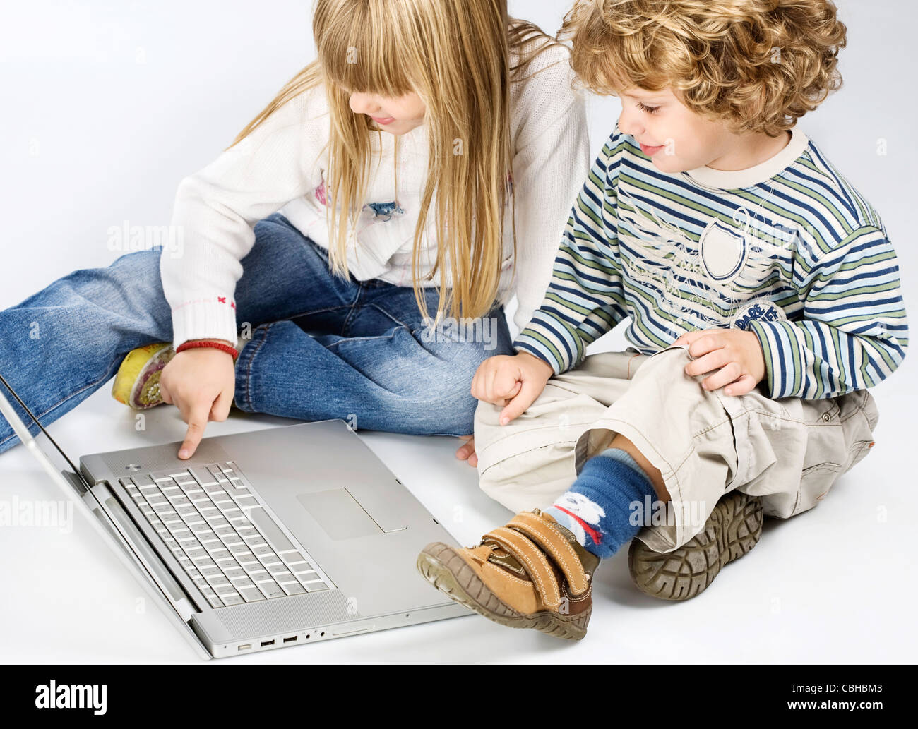 Curl hair boy and blue hair girl trying to turn on computer in front of ...