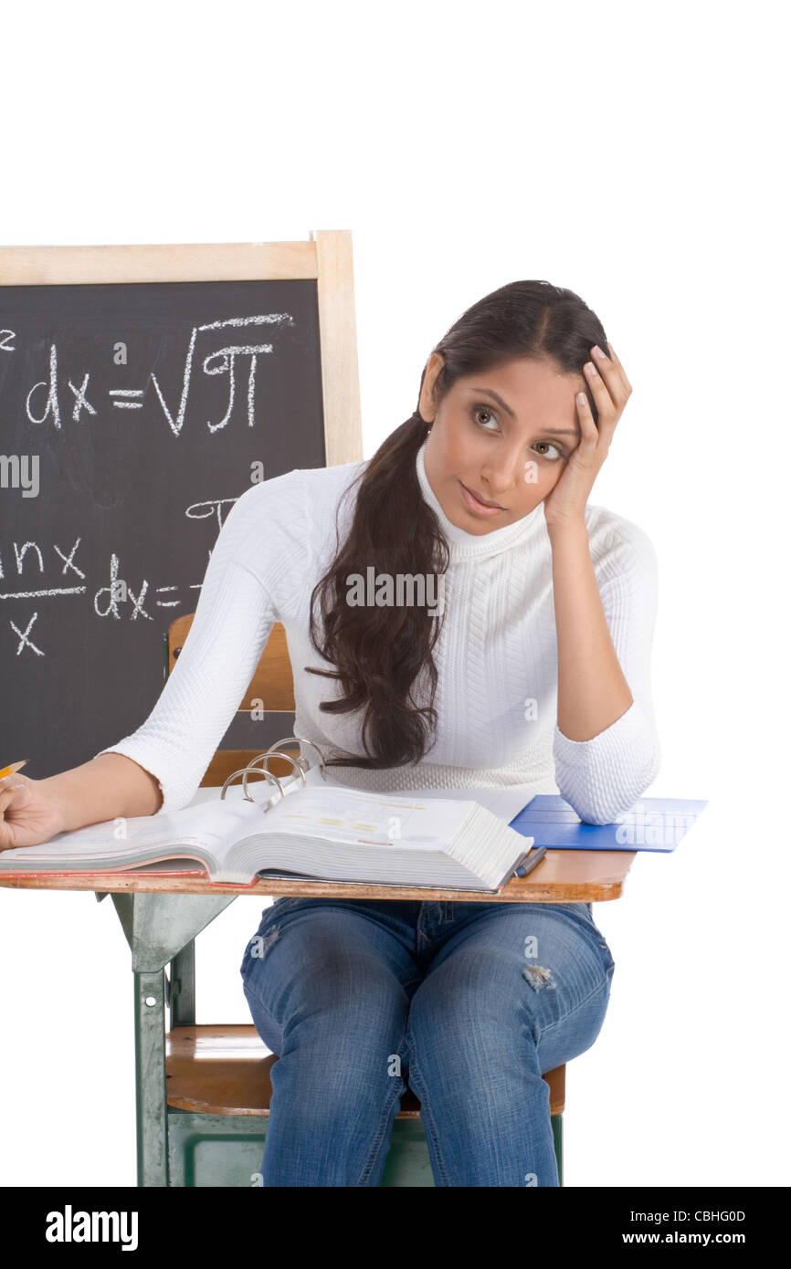 ethnic Indian female student sitting by the desk at math class ...