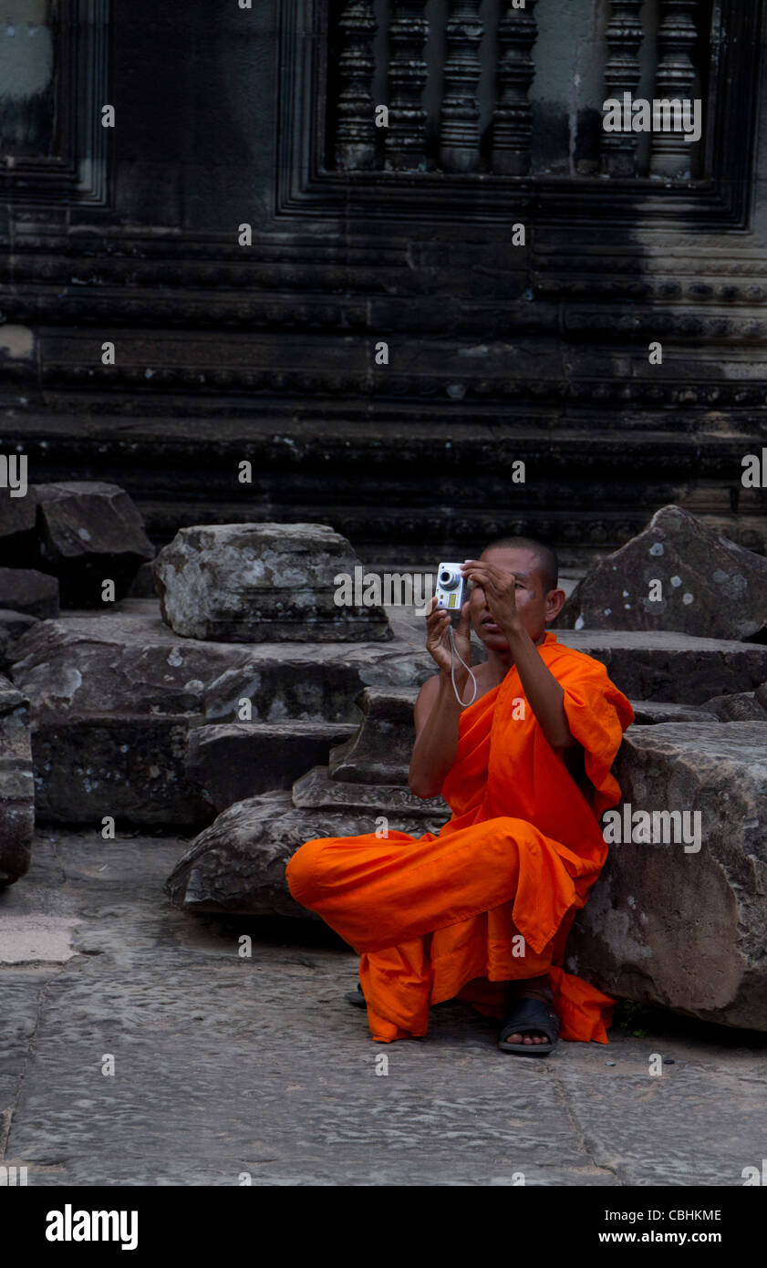 A monk takes a picture with a camera in the inner courtyard of the ...