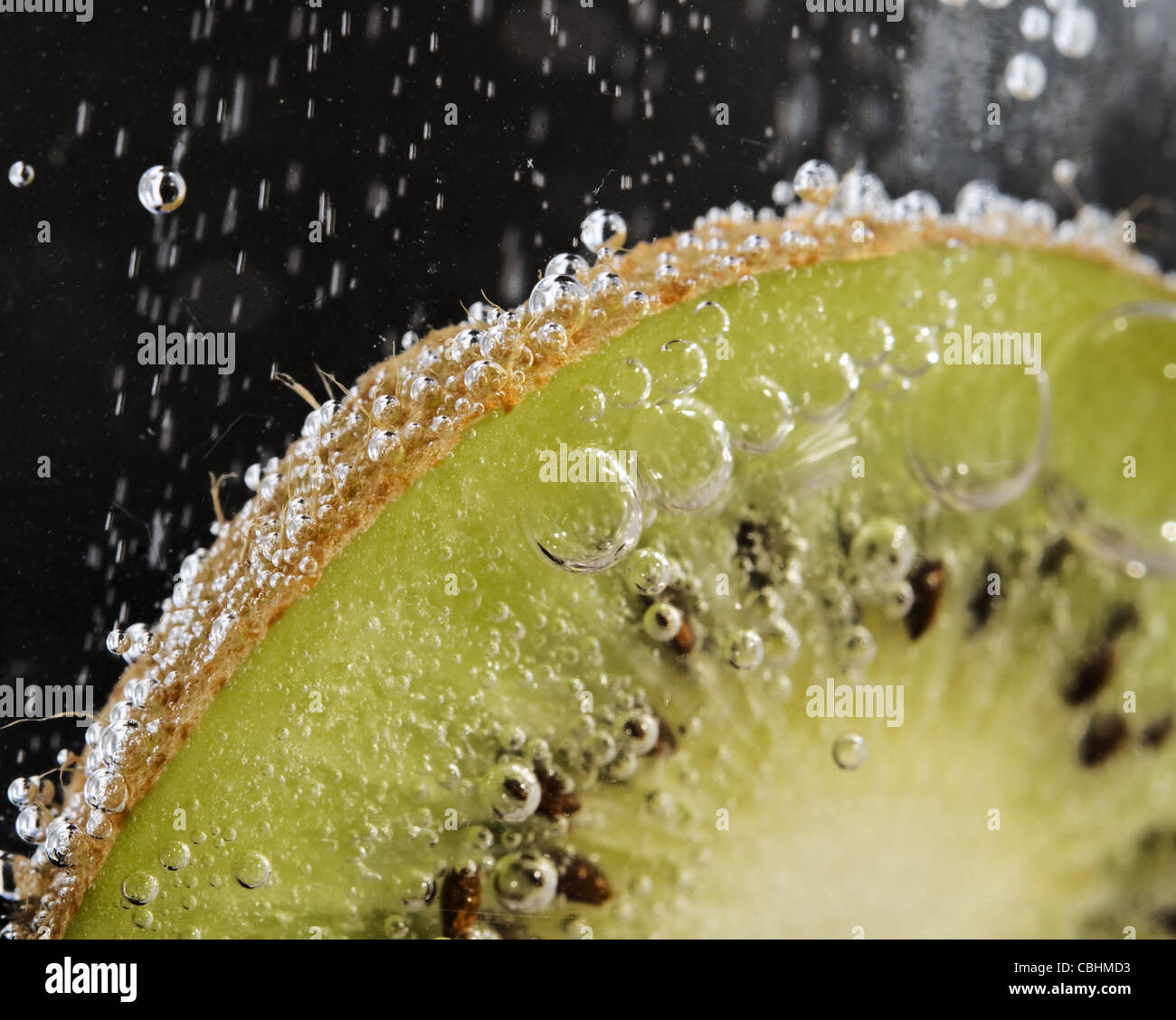 fresh kiwi is in water on a black background Stock Photo - Alamy