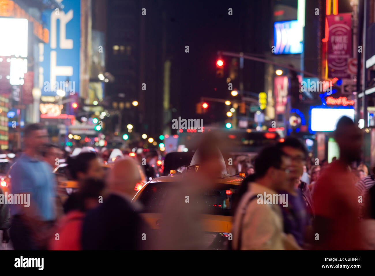 Throngs of people pass through Times Square in New York City at night ...