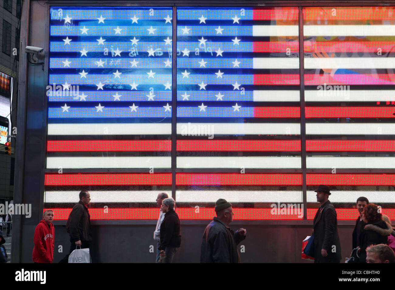 Pedestrians walk past, illuminated Stars & Stripes, United States Flag ...
