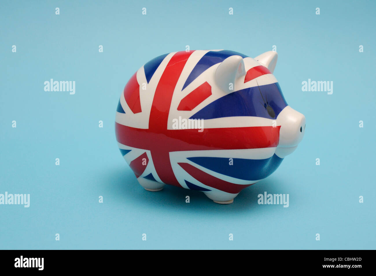 Debt Crisis. Union Jack flag piggy bank photographed against a blue ...