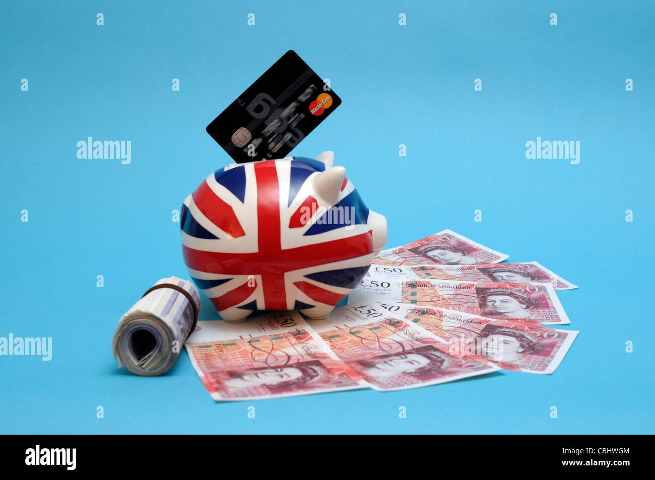 Union Jack piggy bank on top of a blue table with 6 fifty pound bank ...