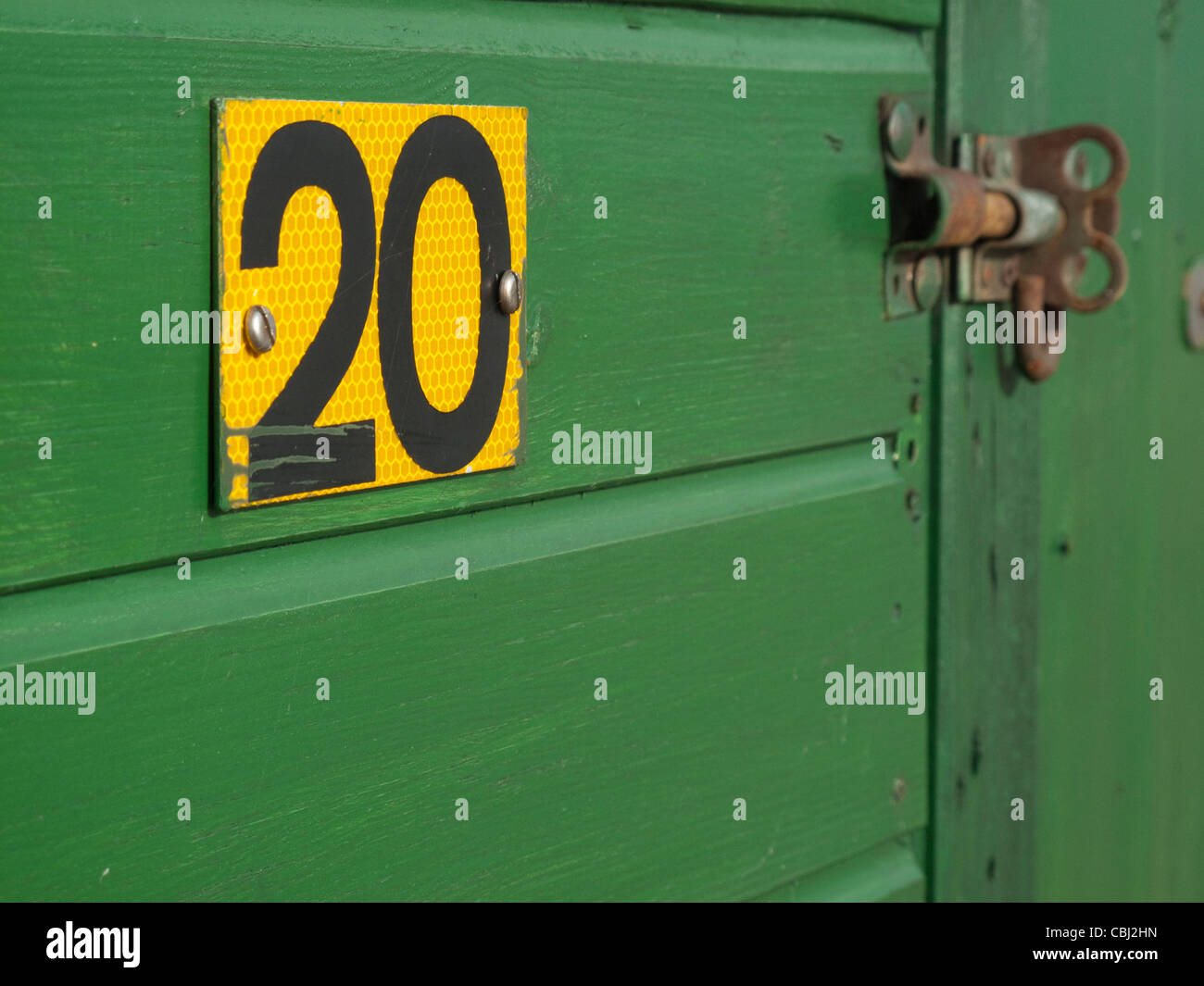 Black on yellow number twenty 20 on a dark green South Coast beach hut ...