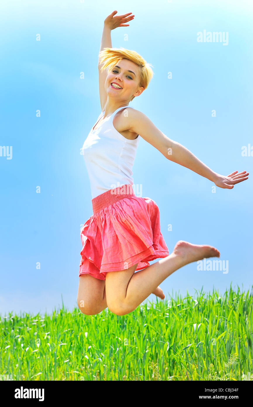 Happy beautiful girl jumping Stock Photo - Alamy