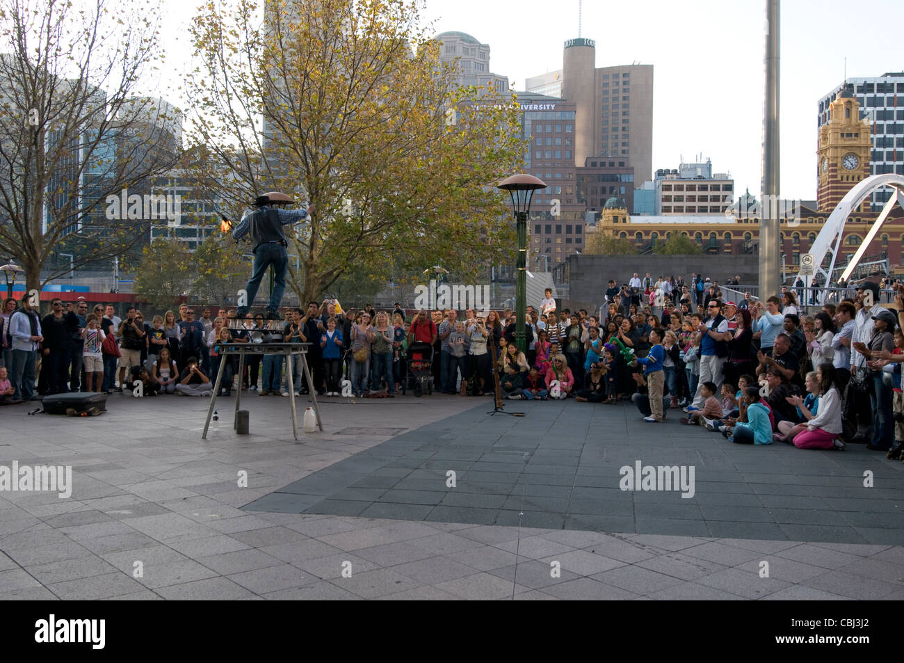 A large crowd watches a street performer in the Southbank in Melbourne ...