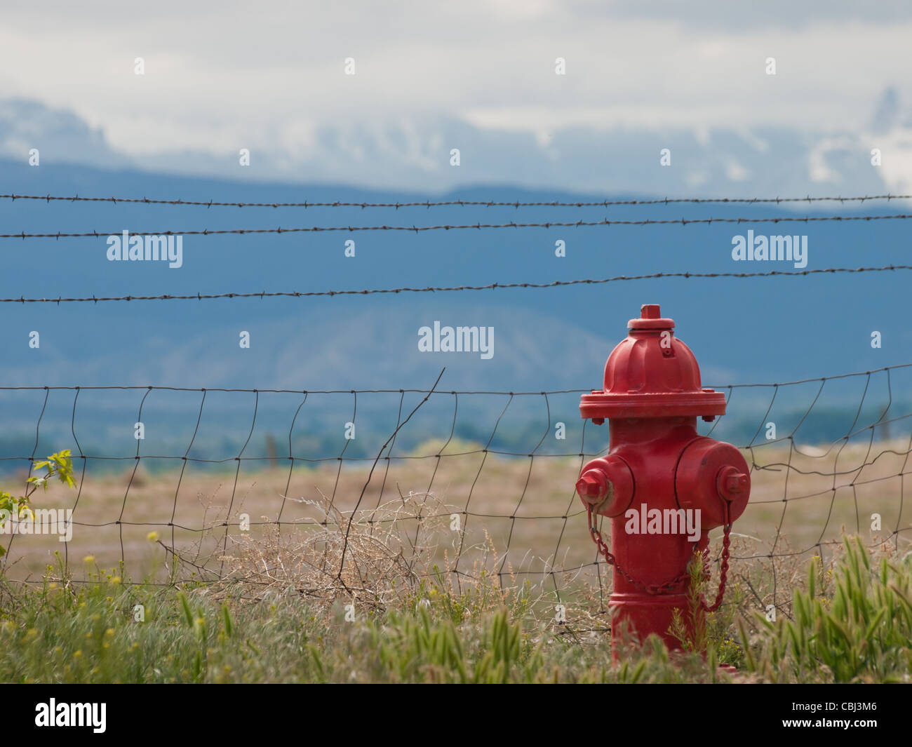 Red fire hydrant on background of snow-covered mountain peaks of Rocky ...