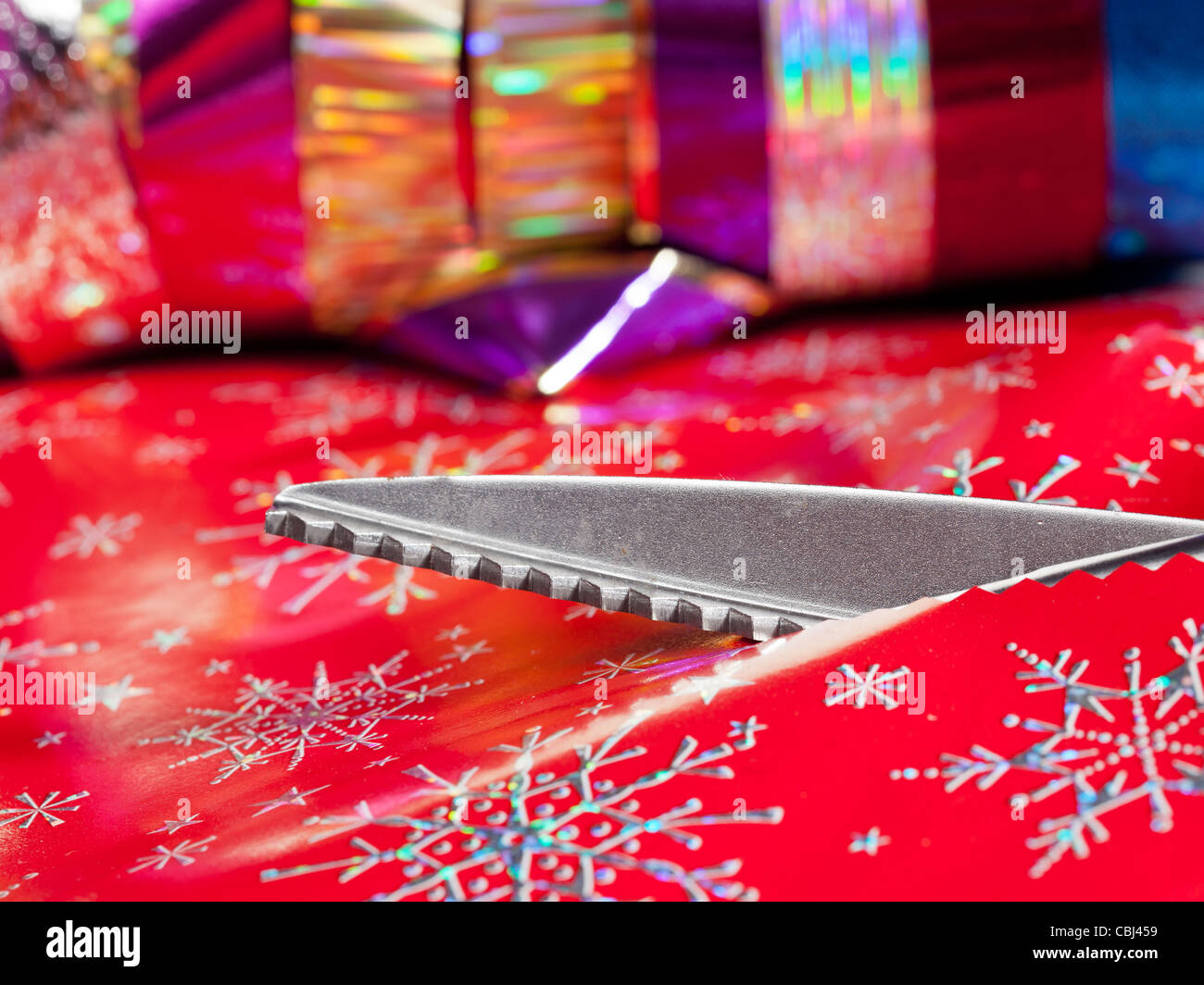 Christmas paper being cut by special scissors to create pattern in the ...