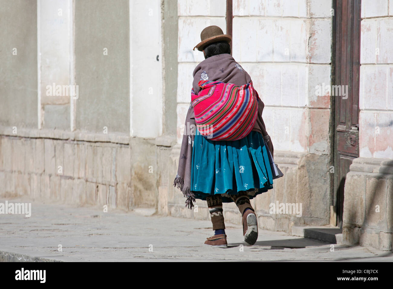 Native Bolivian woman in traditional dress wearing bowler hat and skirt ...