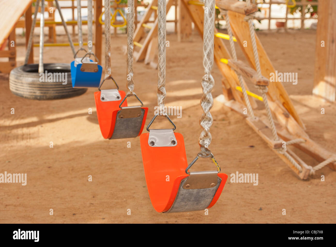 Closeup of colorful plastic swings in a childrens play area at park ...