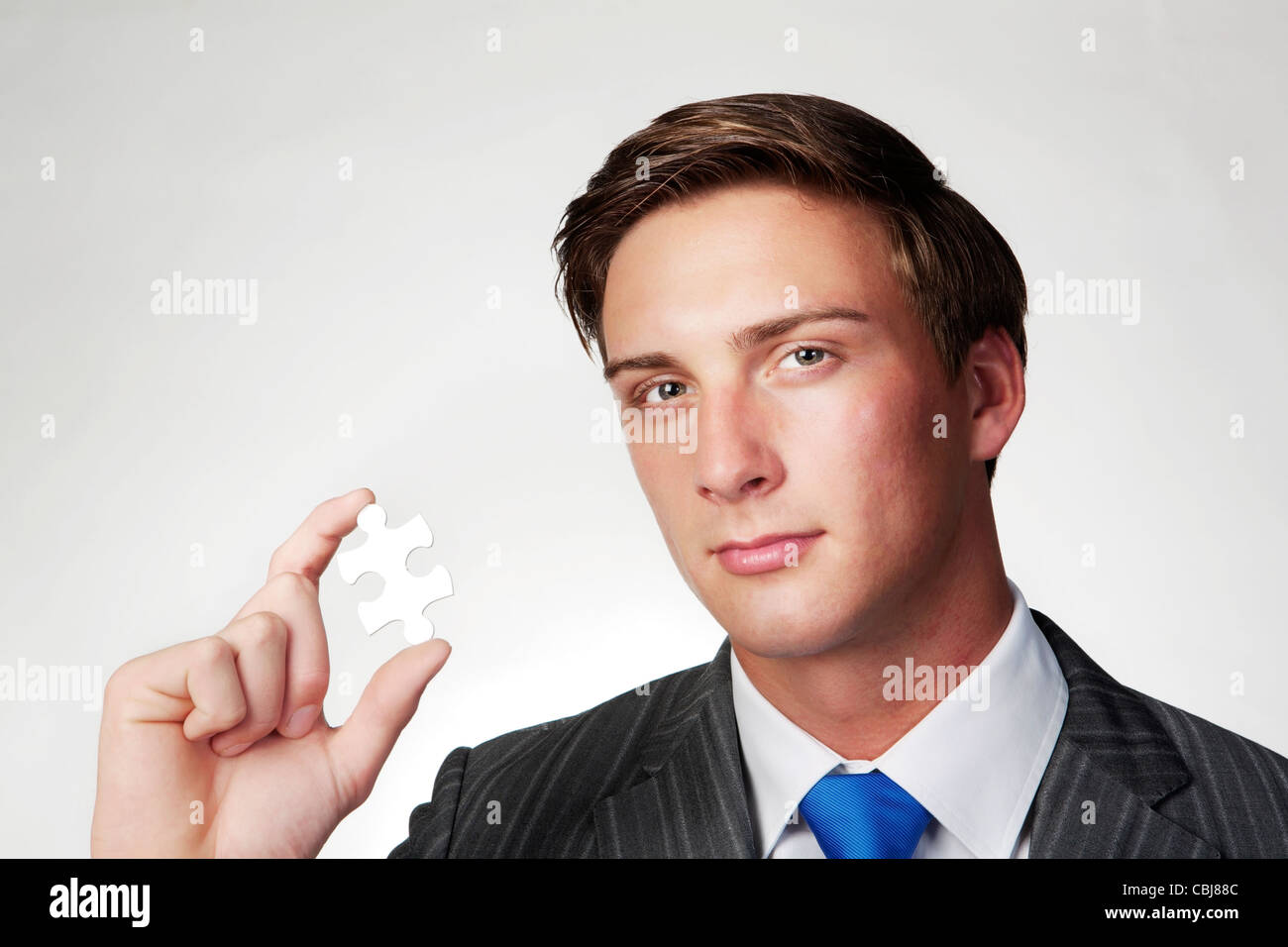 business man holding a jigsaw piece in his hand Stock Photo - Alamy