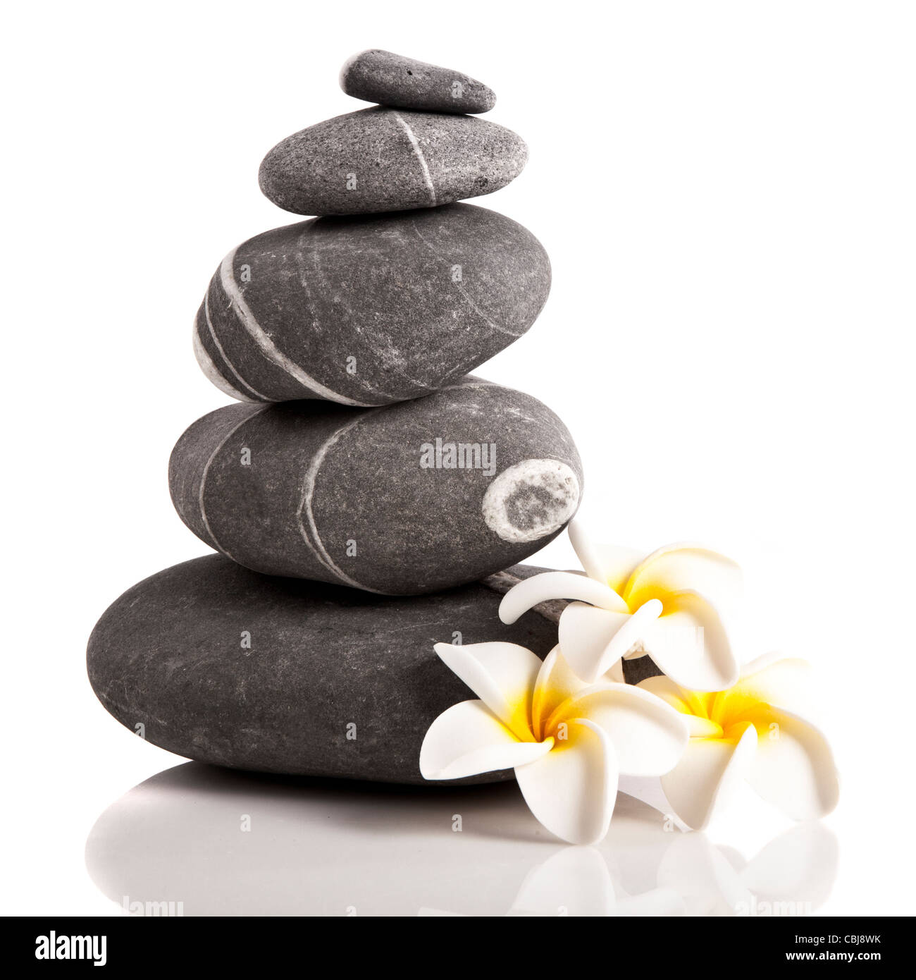 Stones pyramid with a plumeria flower, isolated on white background ...