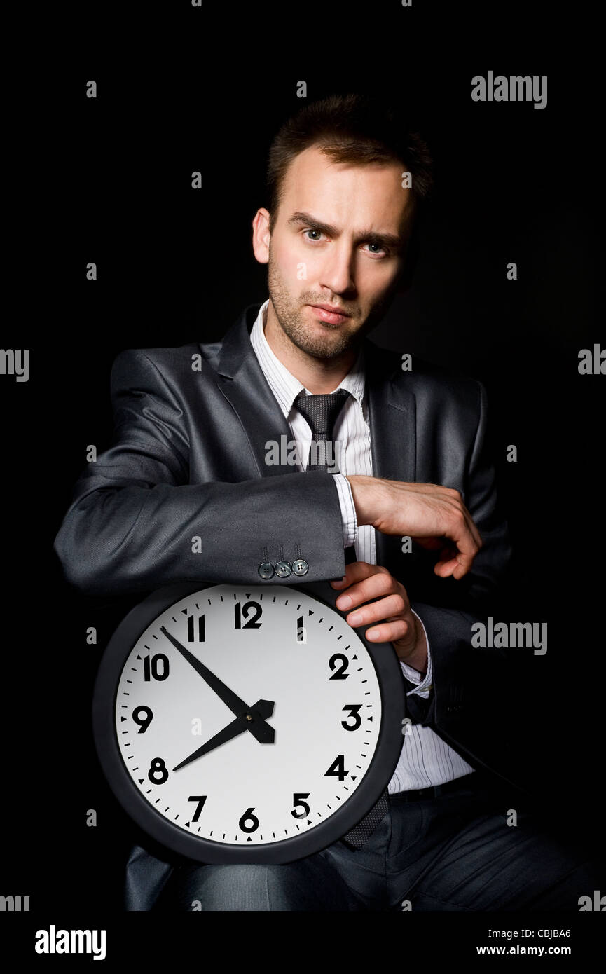 young handsome businessman holding big clock Stock Photo - Alamy