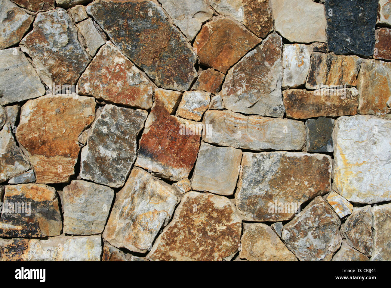 orange, gray, brown, and tan rock wall background Stock Photo - Alamy