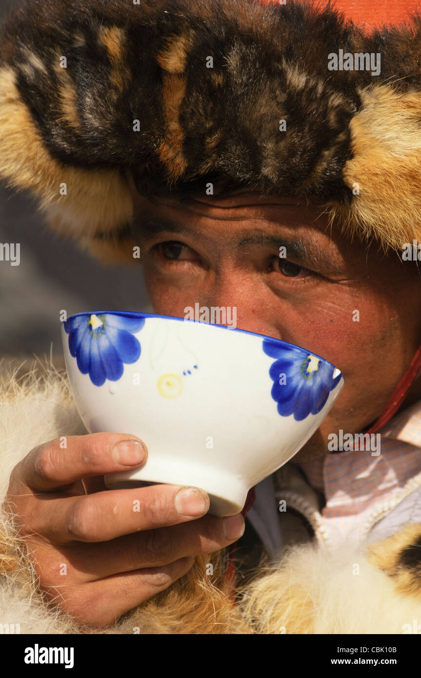 Kazakh eagle hunter drinking milk tea in the Altai Region of Bayan ...