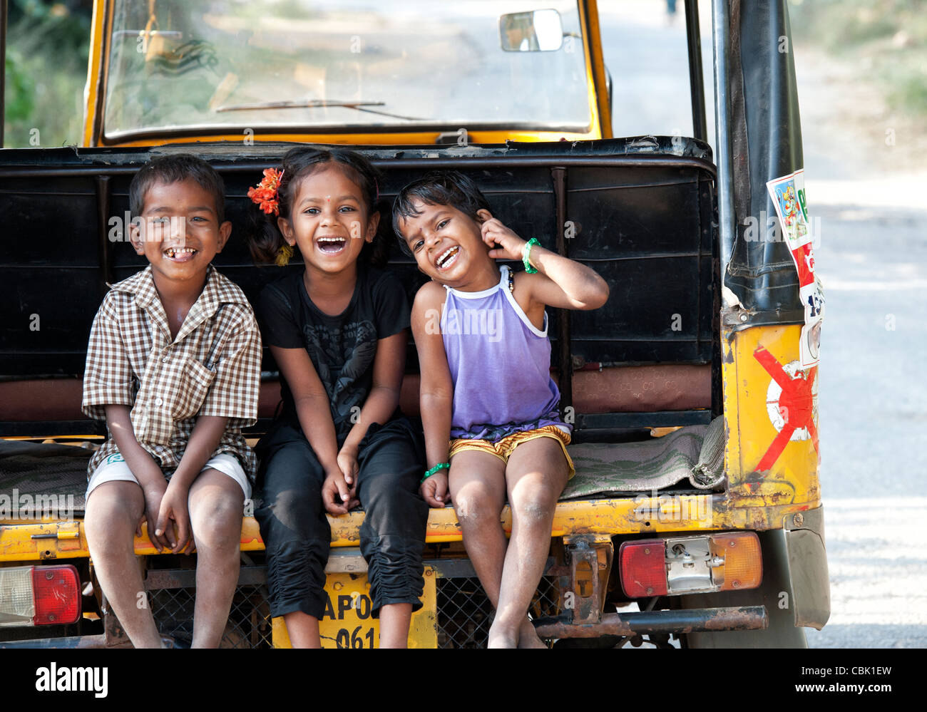 Happy young rural Indian village family children sat in a rickshaw ...