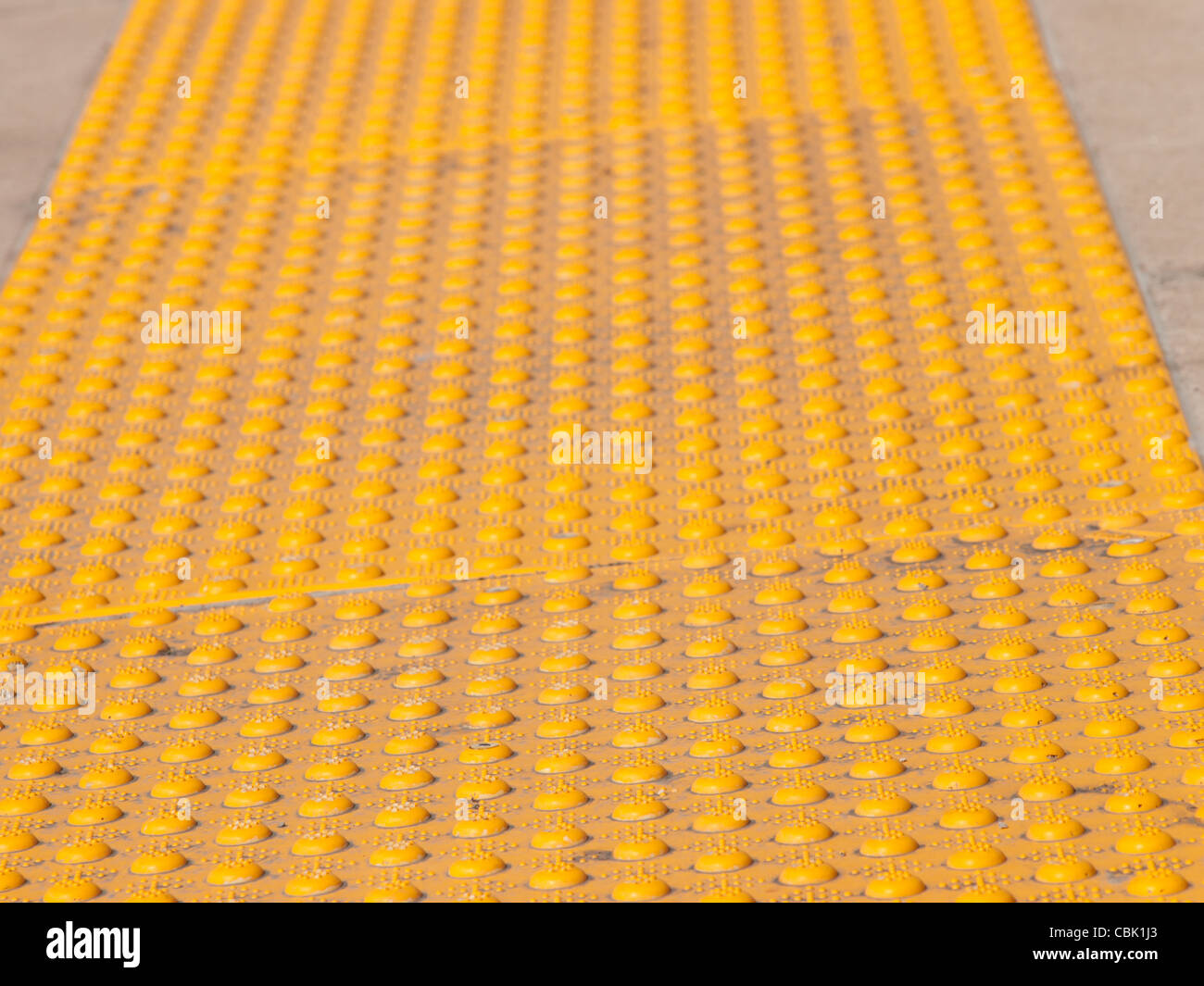 Colored flooring with bumpy texture used to indicate a crossing ...