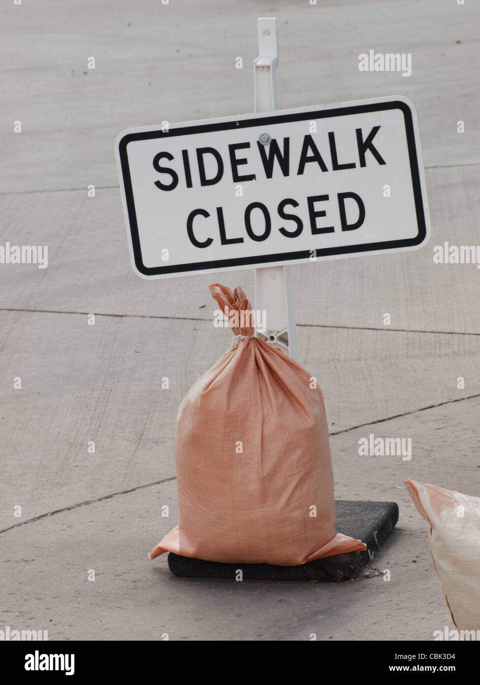 Sidewalk closed construction sign on the road with sand bag Stock Photo ...