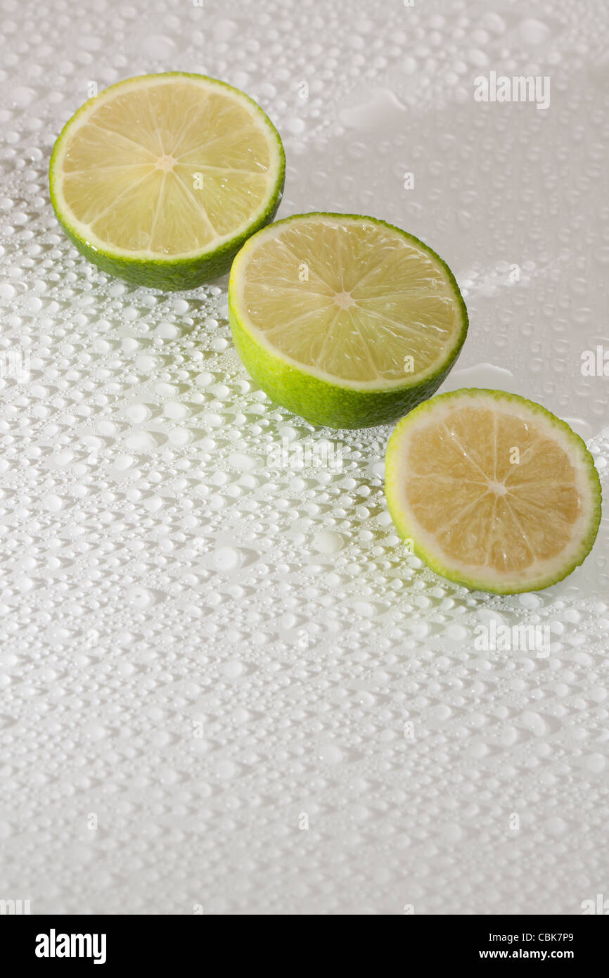 Lime with water drops on white Stock Photo - Alamy