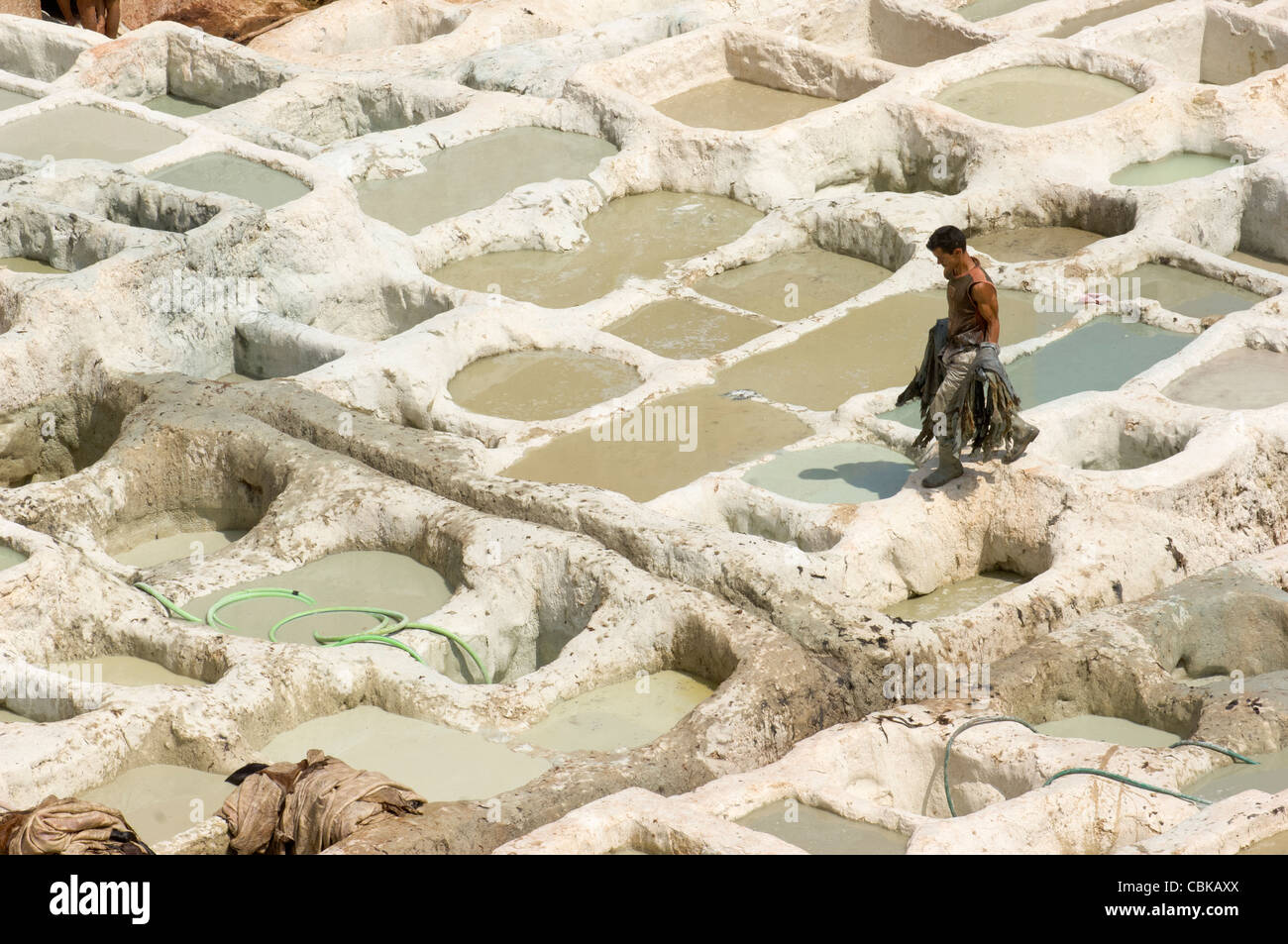 Worker carrying skins across curing pits at the ancient Chouwara ...
