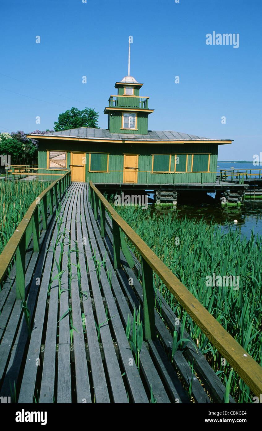 wooden boardwalk through reed leading to a boat house on the Baltic Sea ...