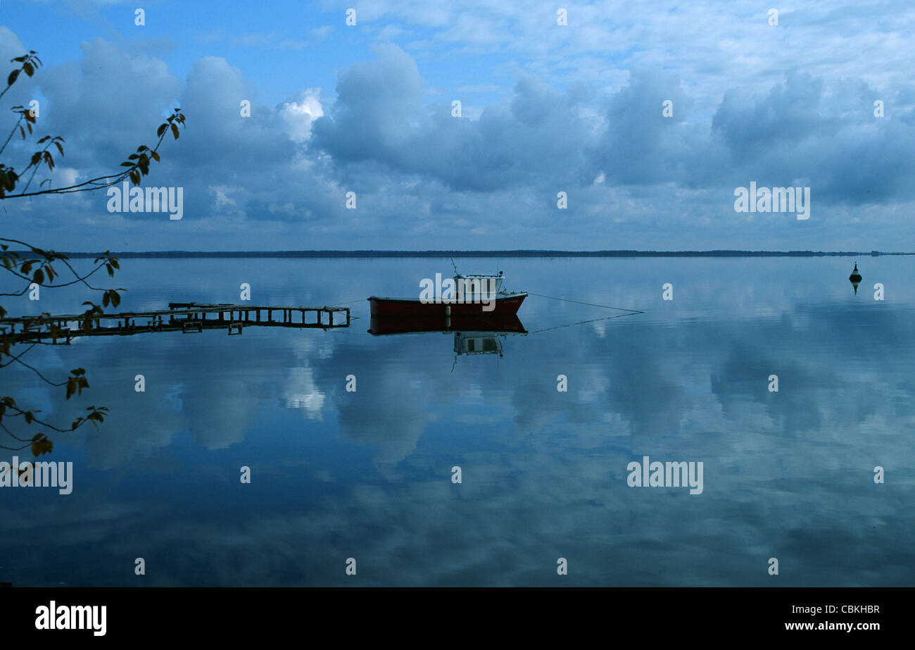 Fishing boat moored at a pier of the Curian lagoon at the Curonian spit ...