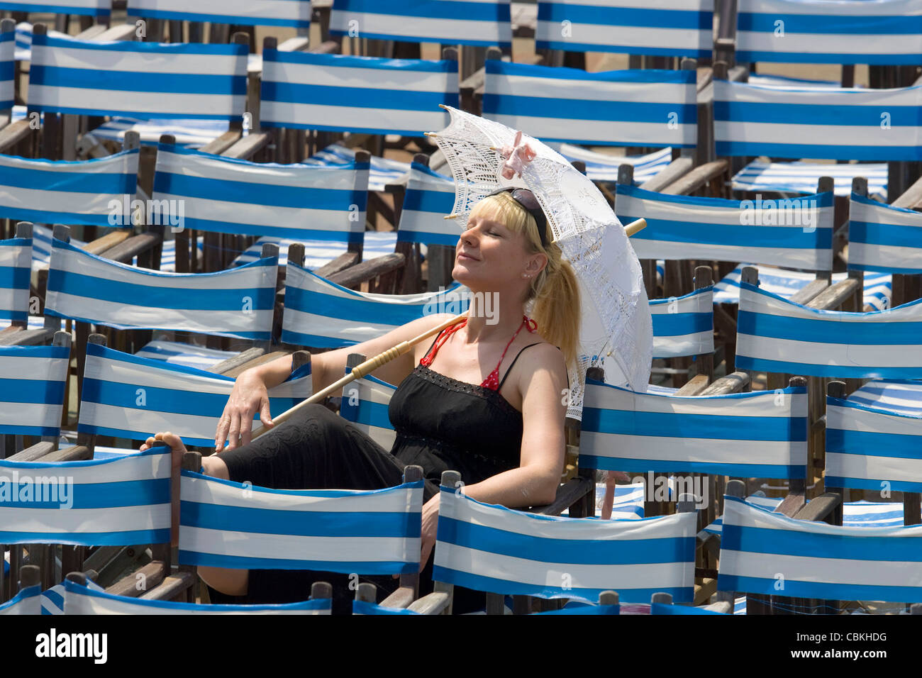 A woman relaxes in the sunshine on Eastbourne seafront. Picture by ...
