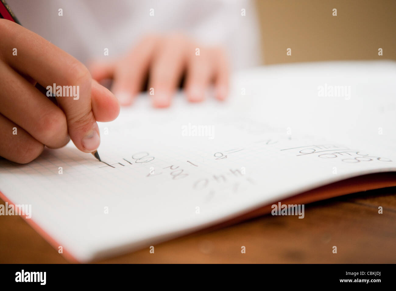 Close up of the hands of a young boy writing in a textbook Stock Photo ...