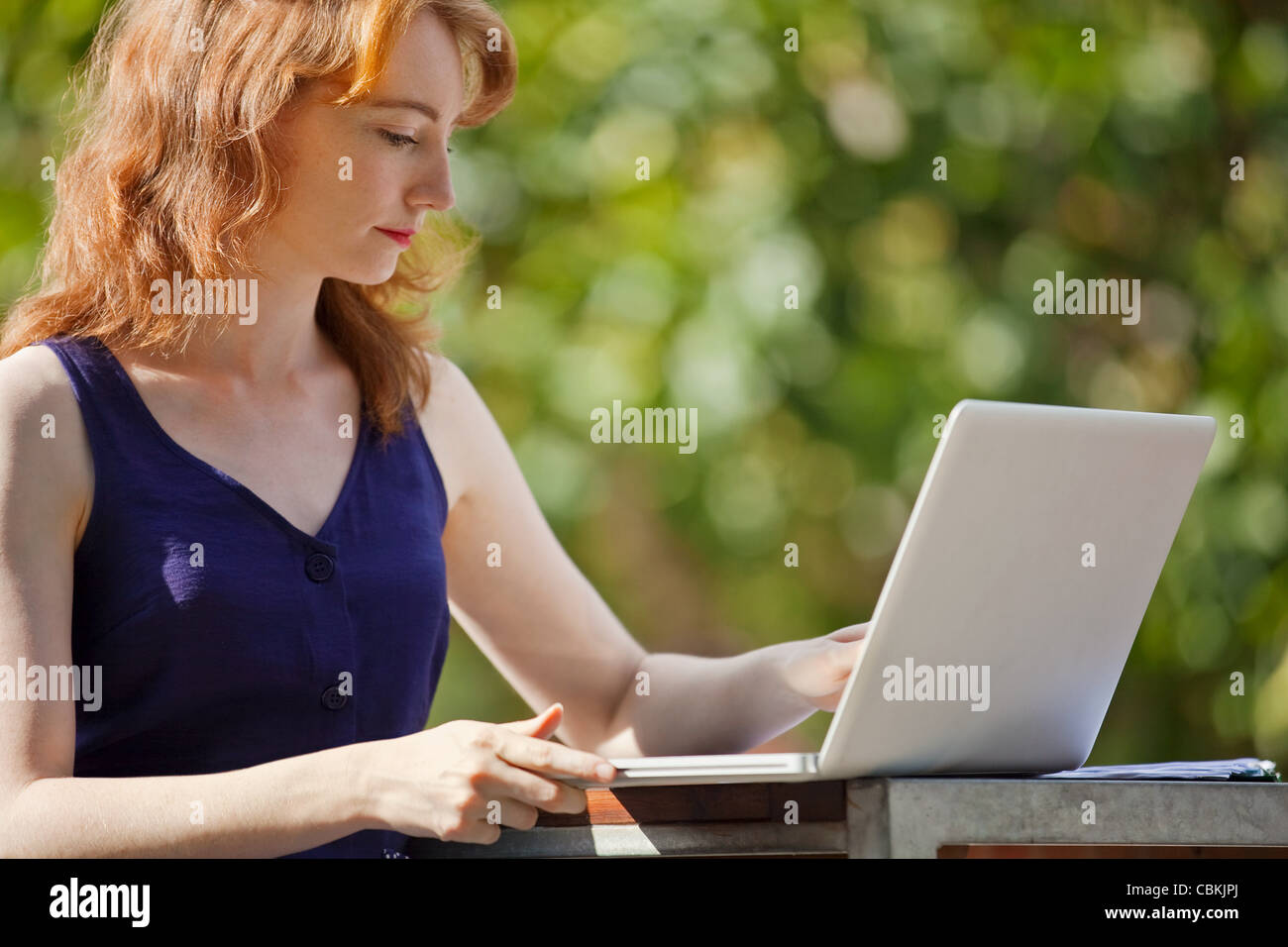 Young woman using a laptop outside Stock Photo - Alamy