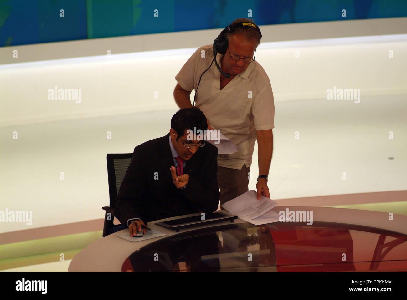 Al Jazeera English anchor delivering the news at the Doha HQ of AJE ...