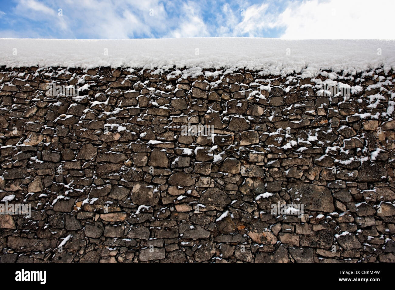 Snow on top of stone wall Stock Photo - Alamy
