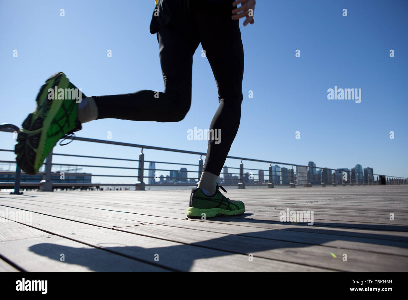 View of an athlete's legs running across walkway Stock Photo - Alamy