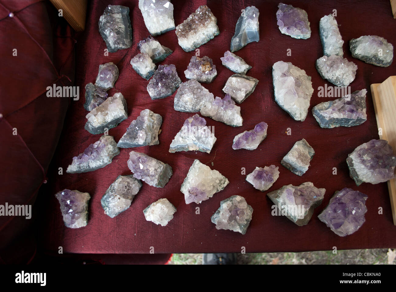 amethyst and other crystals for sale scattered across a red cloth on a ...