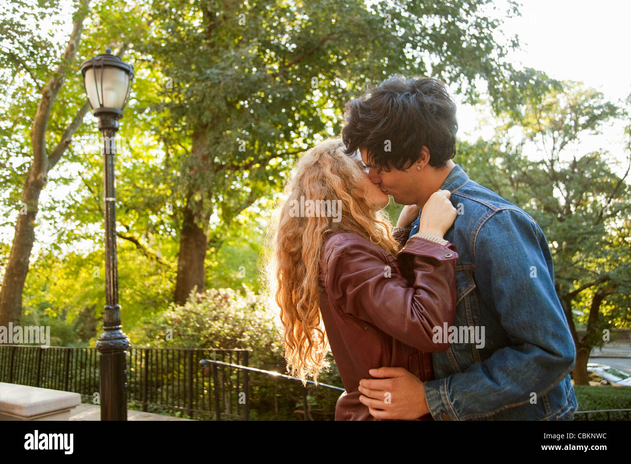 Young couple kissing in park Stock Photo - Alamy