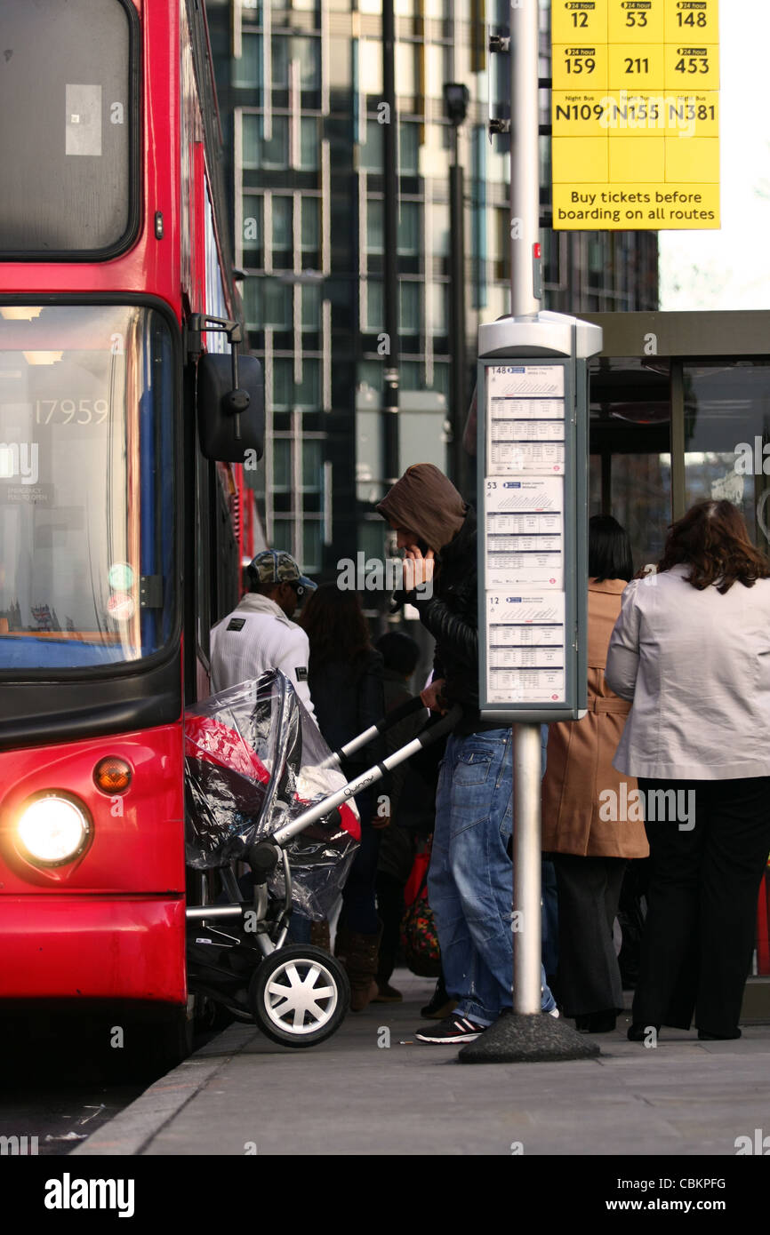 a person boarding a red London bus with a pushchair Stock Photo - Alamy