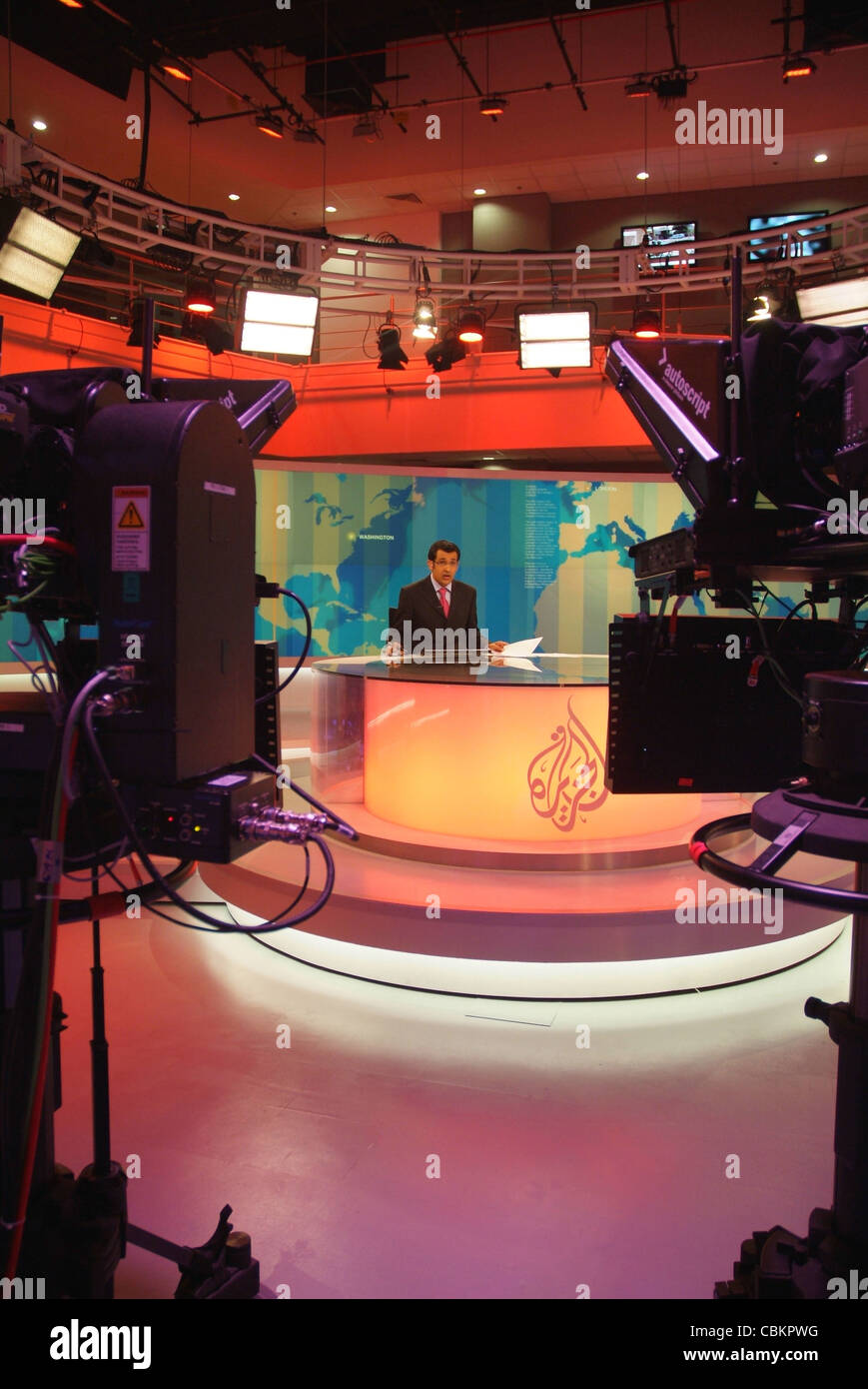 Al Jazeera English anchor delivering the news at the Doha HQ of AJE ...